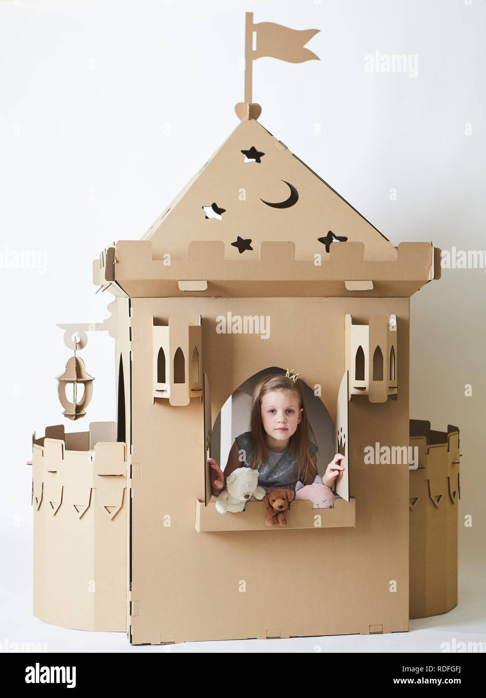Beautiful little girl in princess dress playing with her toy castle ...