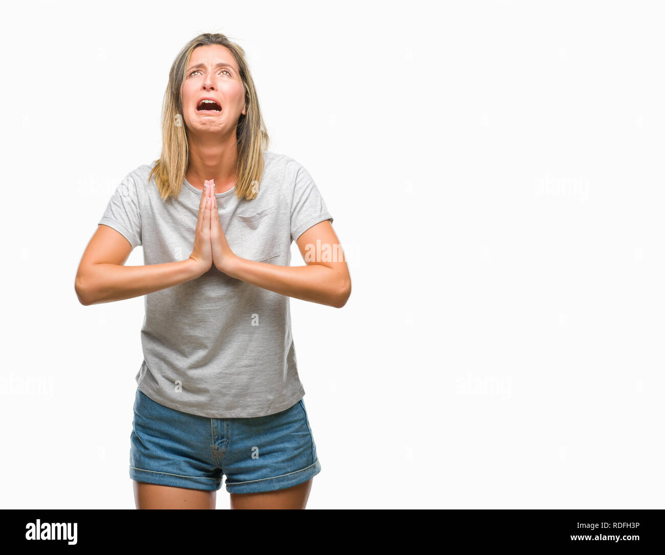 Young beautiful woman over isolated background begging and praying with ...