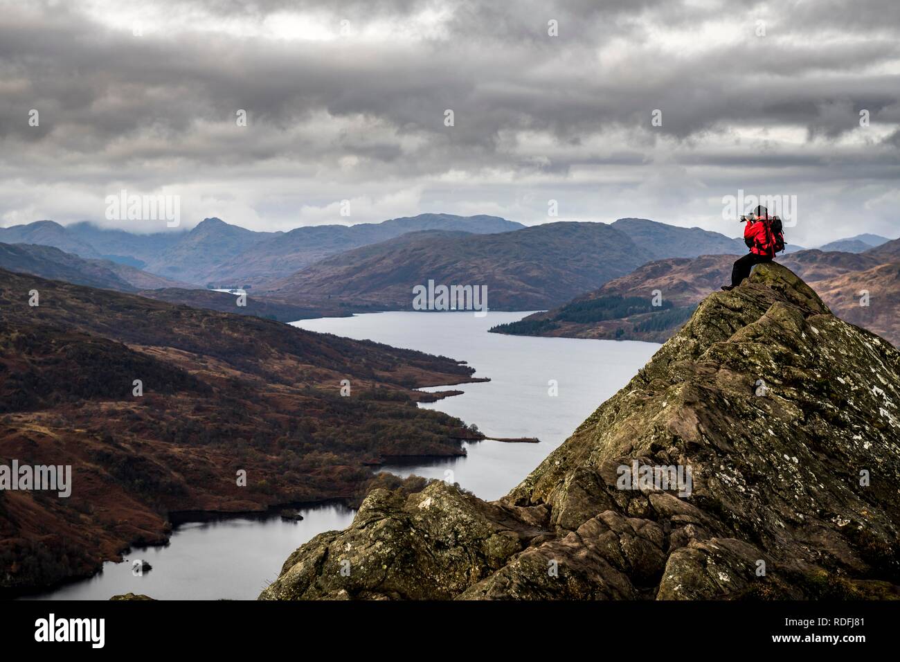 Summit of Ben Aán with photographer, in the background Loch Katrine and ...