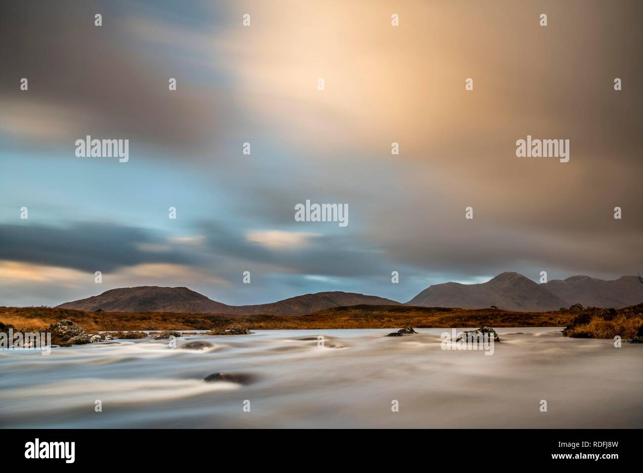 River Ba with mountain peaks in the background and dramatic clouds ...