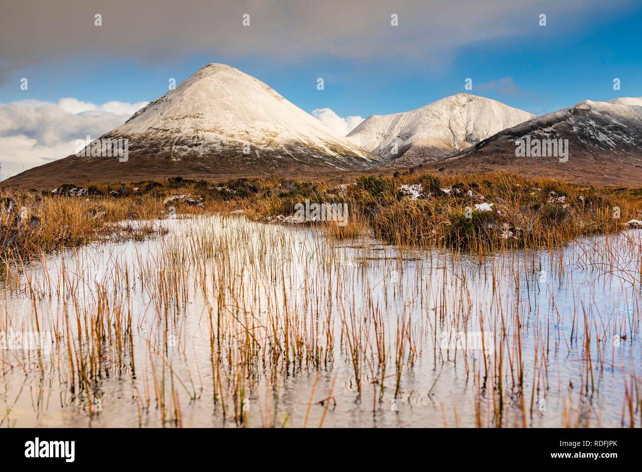 Moor landscape with snow-covered peaks of the Cullins Mountains in ...
