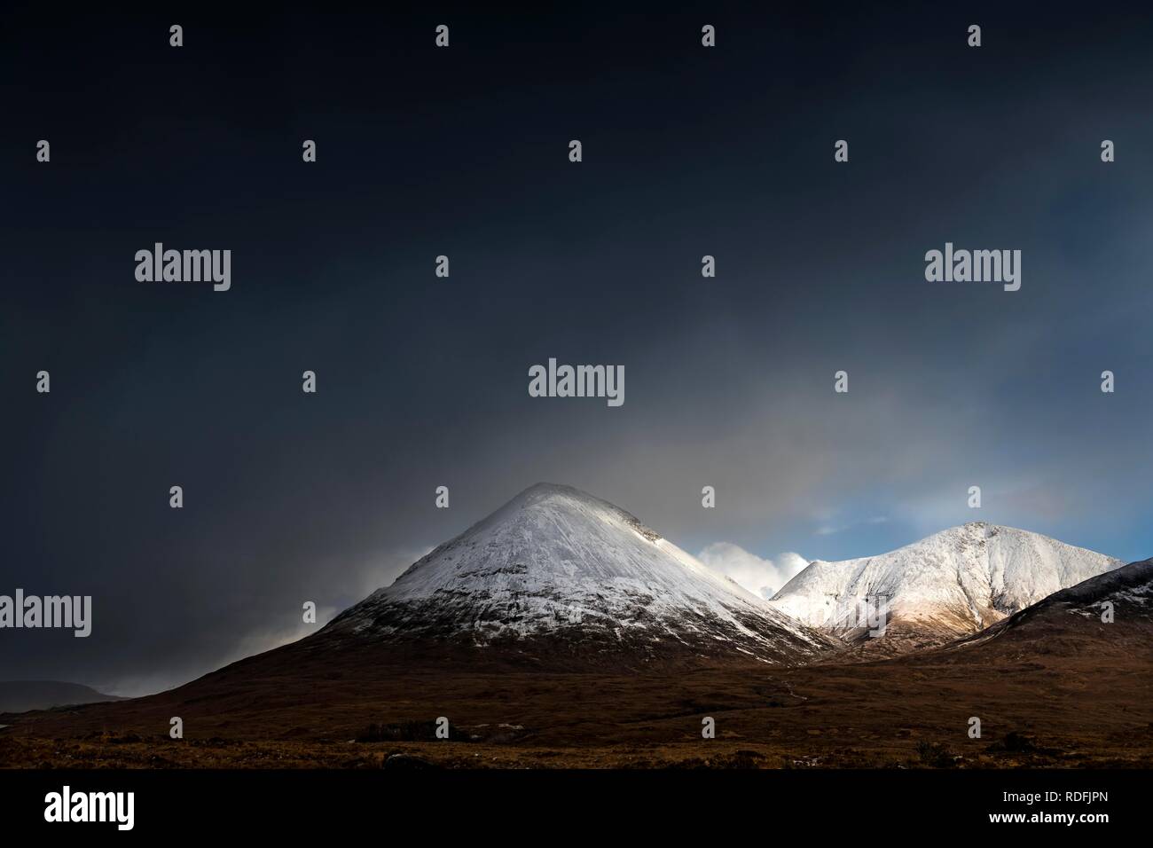 Moor landscape with snow-covered peaks of the Cullins Mountains in ...