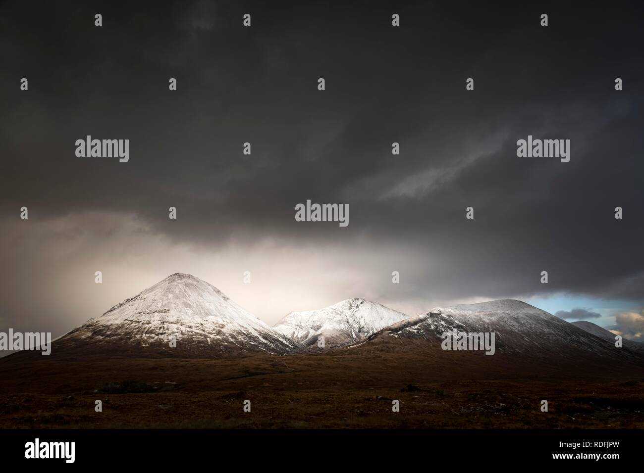 Moor landscape with snow-covered peaks of the Cullins Mountains in ...