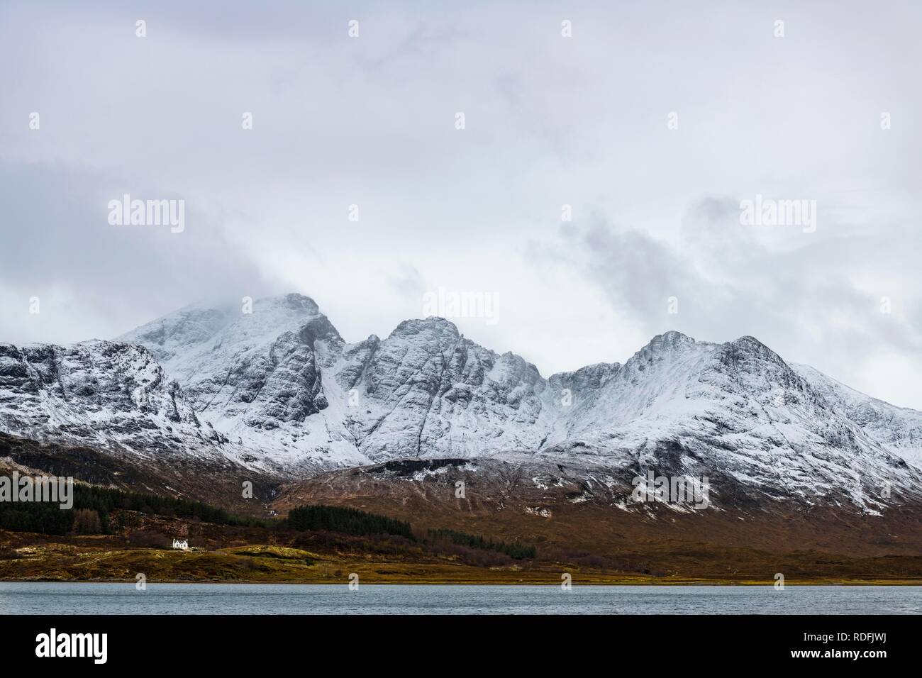 Loch Slapin with small house in Highland landscape with snowy Cullin ...