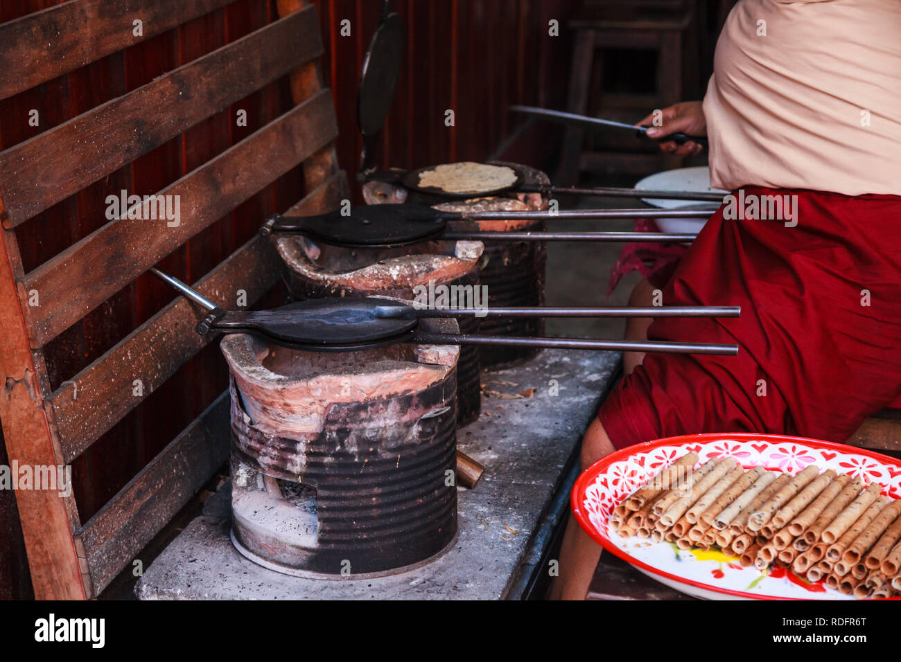 Woman baking Thong Muan (Thai Crispy Coconut Wafer Rolls snack similar ...