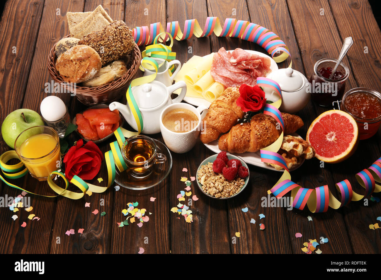 breakfast on table with bread buns, croissants, streamers, coffe and ...