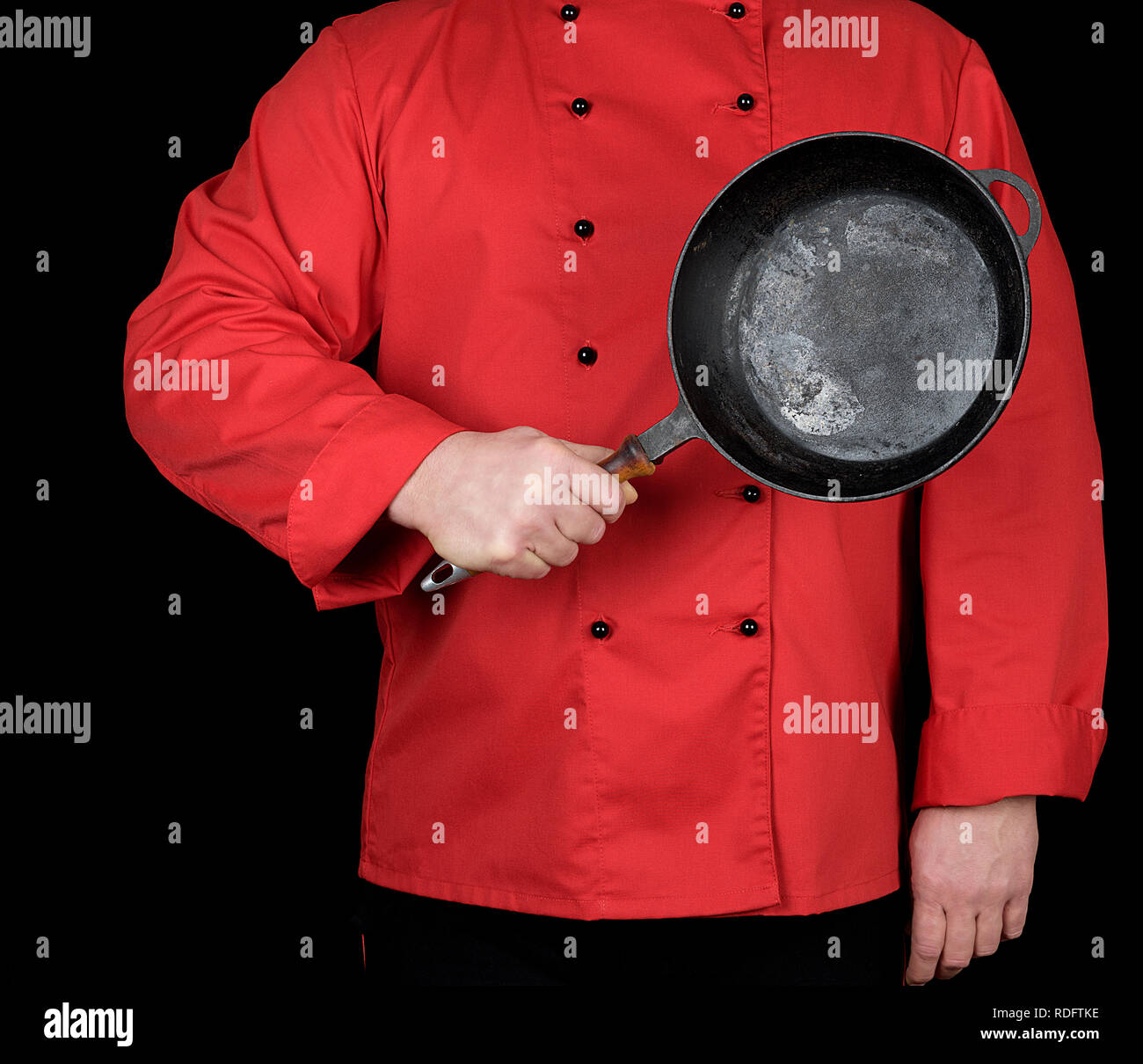 cook in red uniform holding an empty round black frying pan, black ...