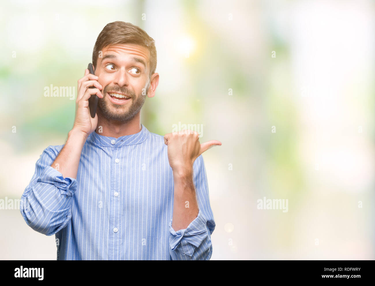 Young handsome man speaking on the phone over isolated background ...