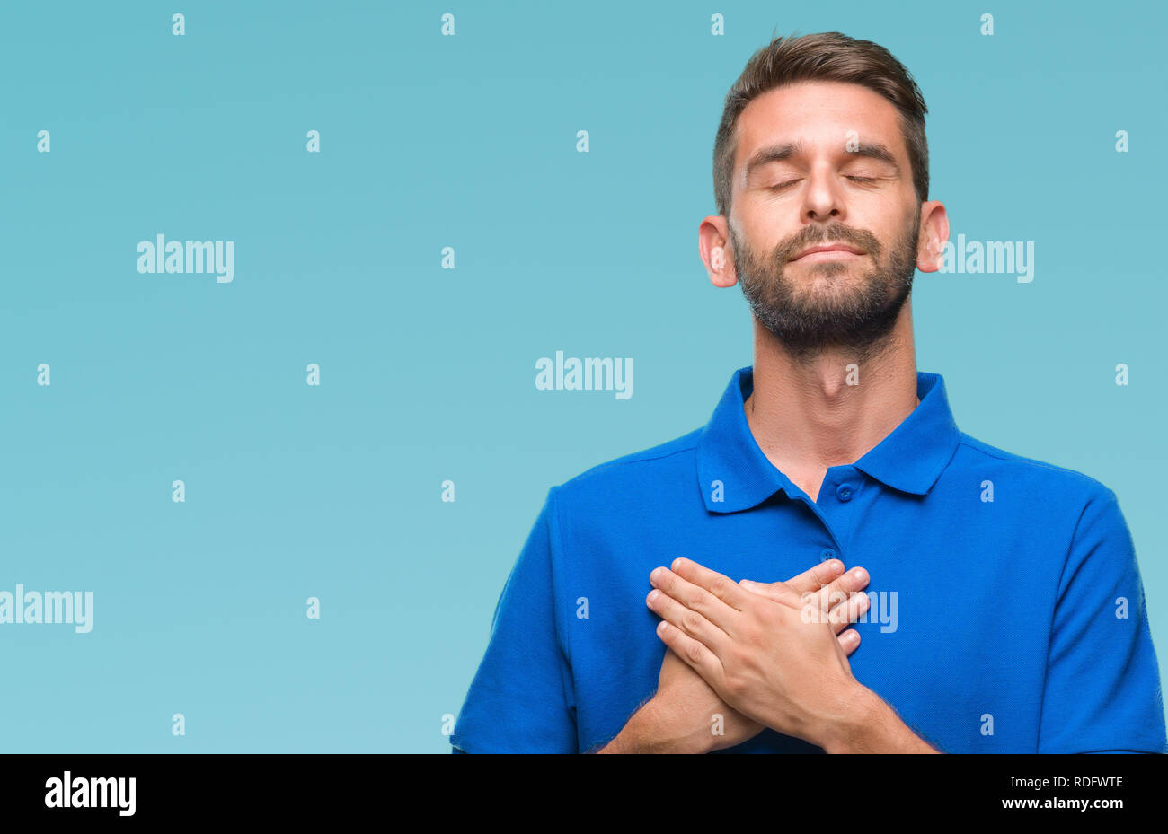 Young handsome man over isolated background smiling with hands on chest ...