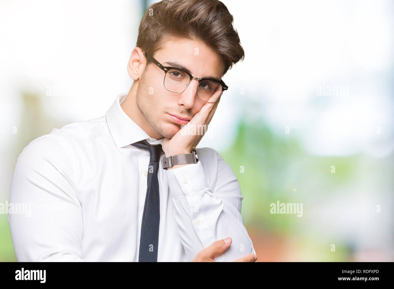 Young business man wearing glasses over isolated background thinking ...