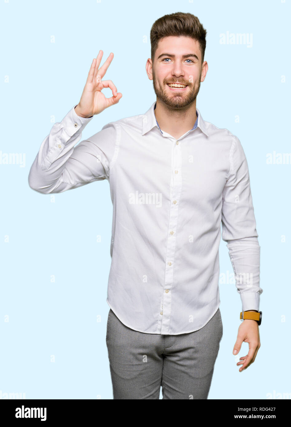 Young handsome business man smiling positive doing ok sign with hand ...