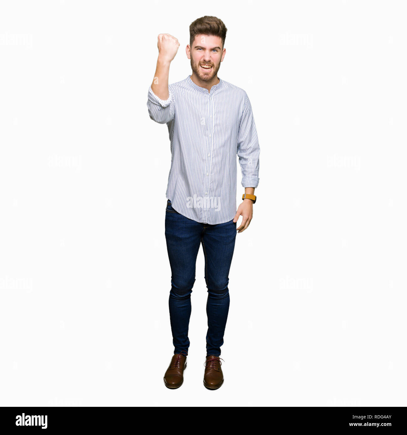 Young handsome man angry and mad raising fist frustrated and furious ...
