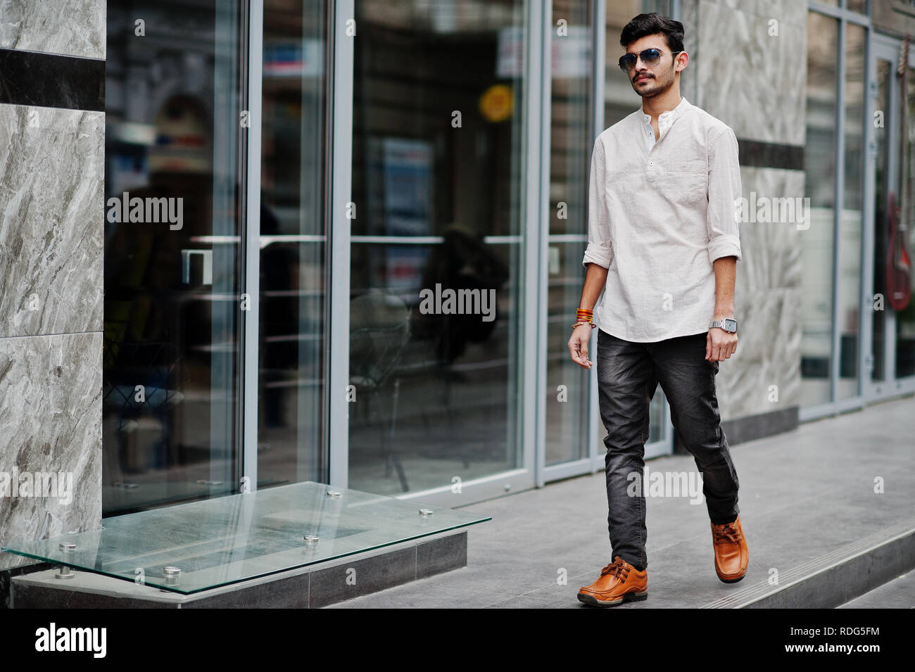 Stylish indian model man in casual clothes and sunglasses posed outdoor ...