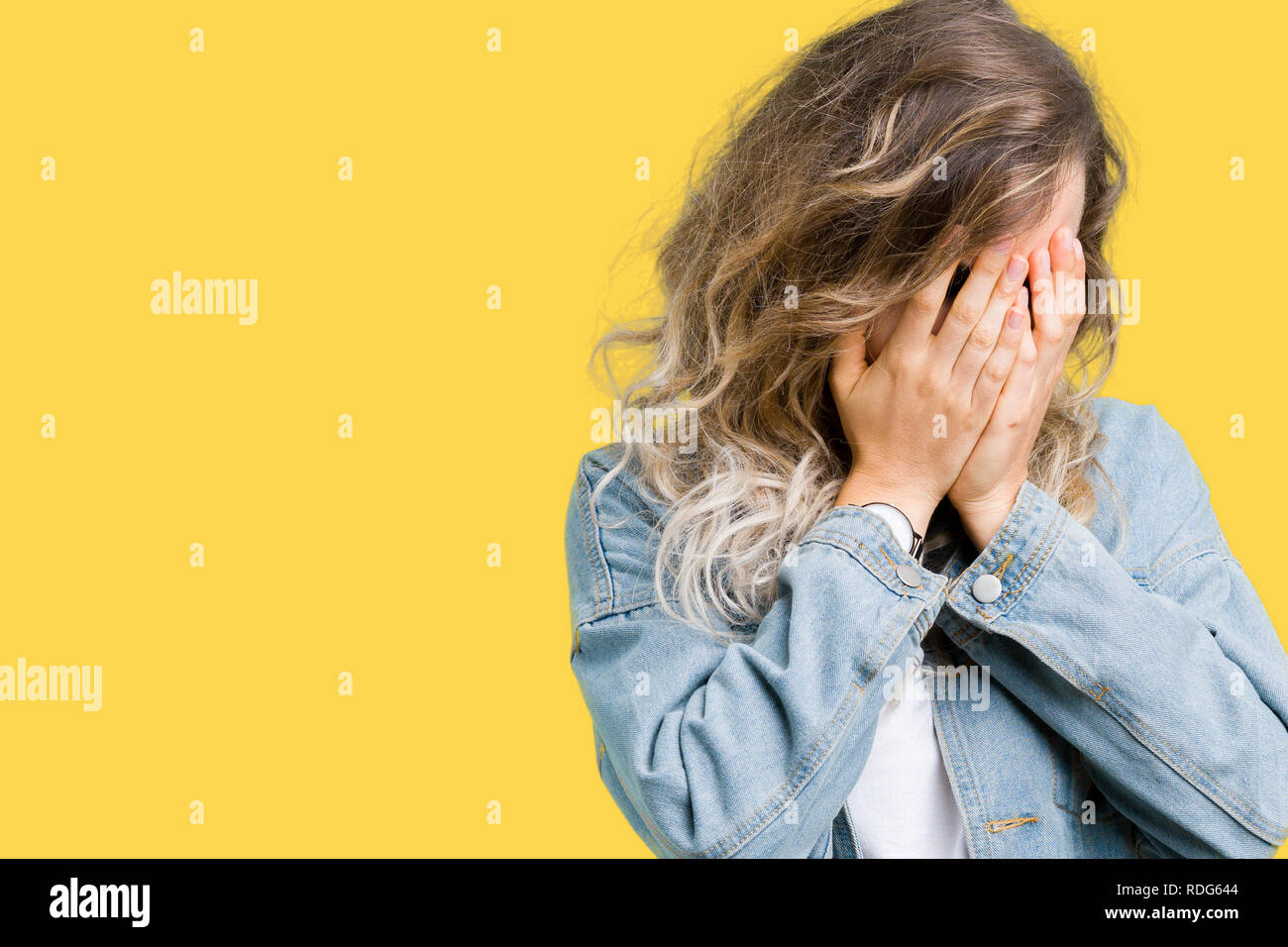 Beautiful young blonde woman wearing denim jacket over isolated ...