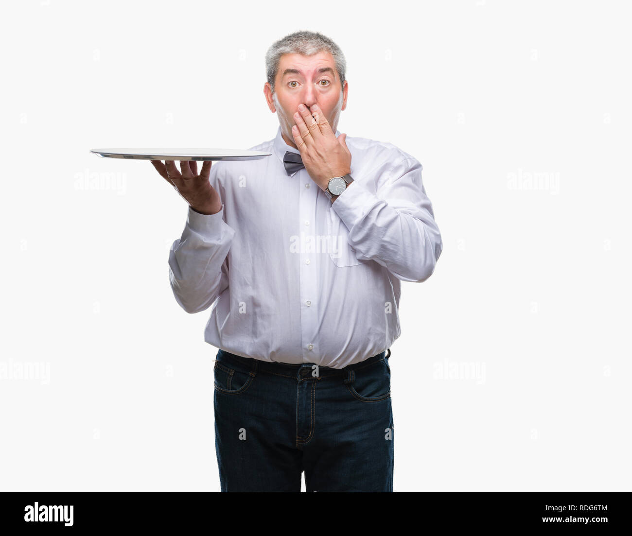 Handsome senior waiter man holding silver tray over isolated background ...