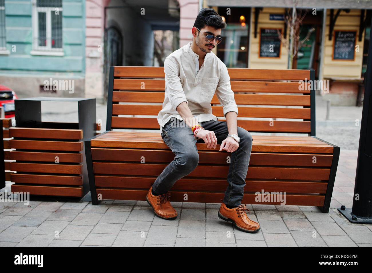 Stylish indian model man in casual clothes and sunglasses posed outdoor at street of India and ...