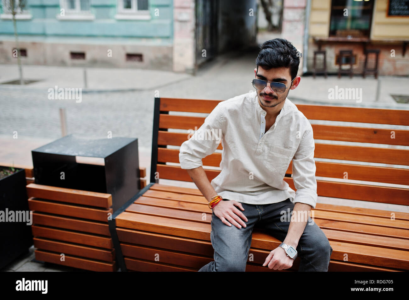 Stylish indian model man in casual clothes and sunglasses posed outdoor at street of India and ...