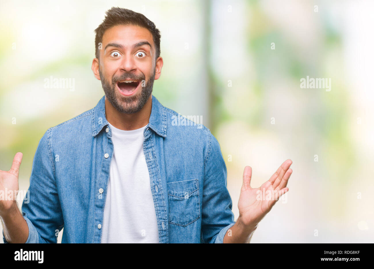Adult hispanic man over isolated background celebrating crazy and ...