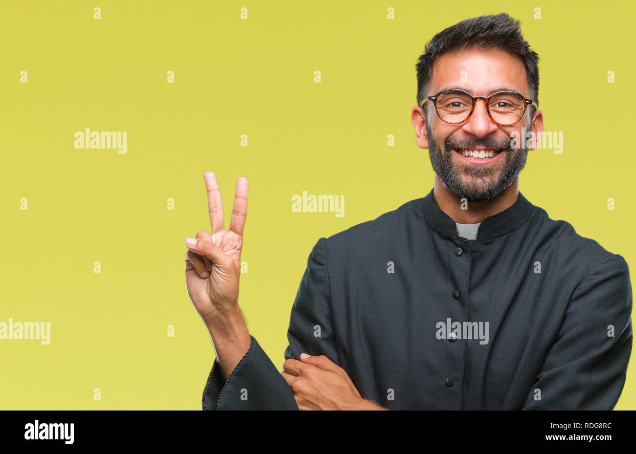 Adult hispanic catholic priest man over isolated background smiling ...