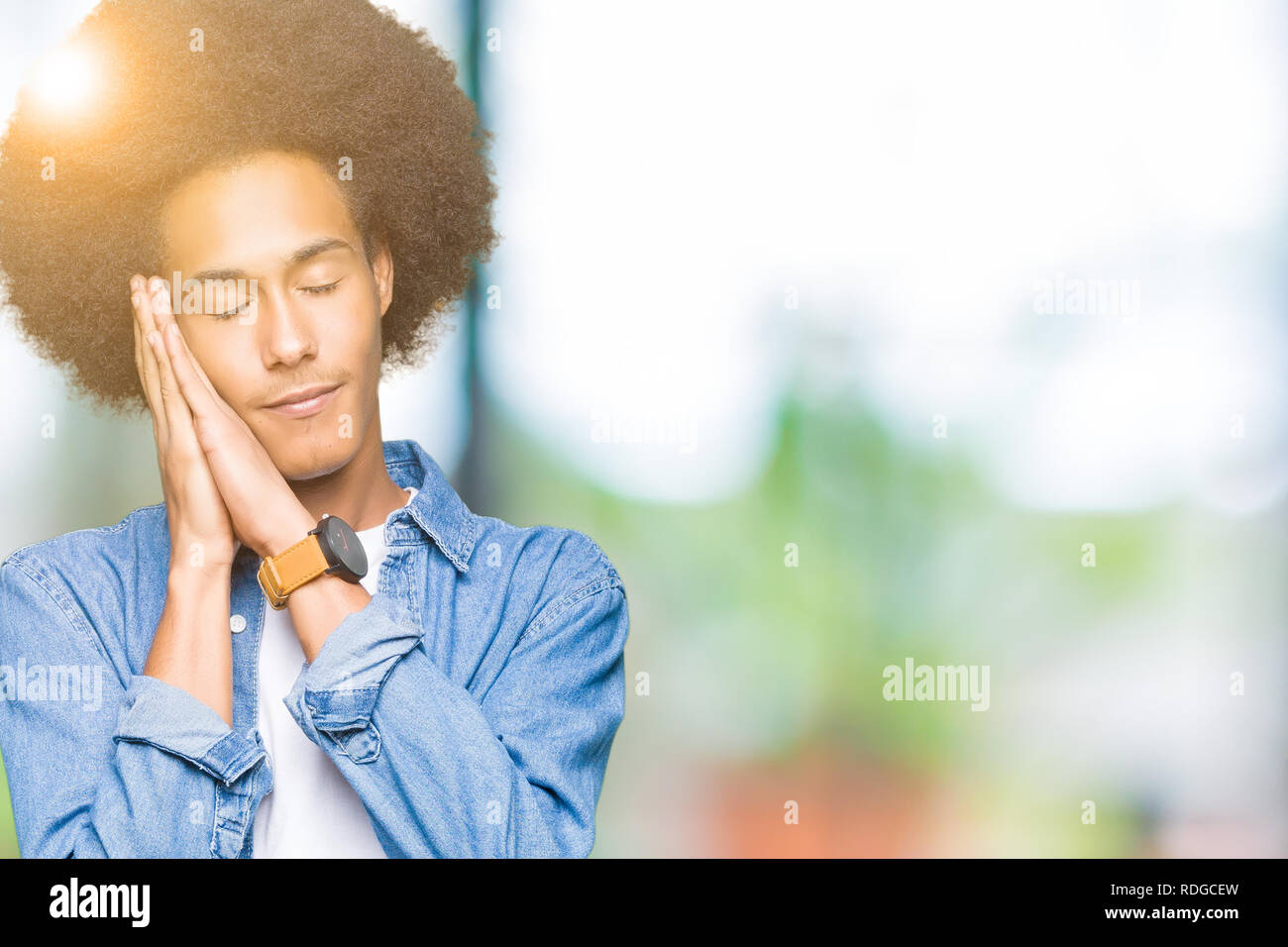 Young african american man with afro hair sleeping tired dreaming and ...