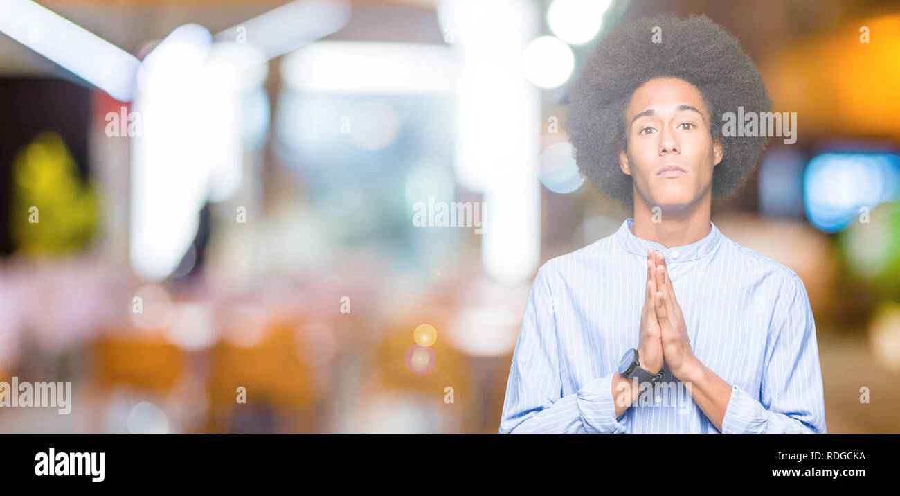Young african american man with afro hair begging and praying with ...