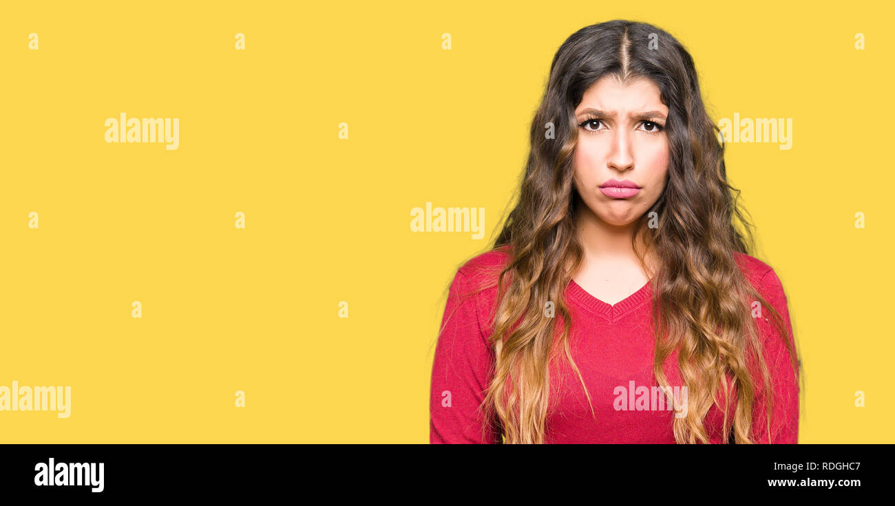 Young beautiful woman wearing red sweater depressed and worry for ...