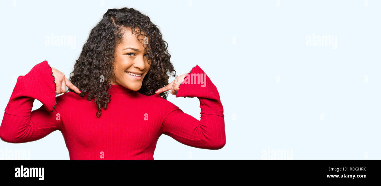 Young beautiful woman with curly hair looking confident with smile on ...