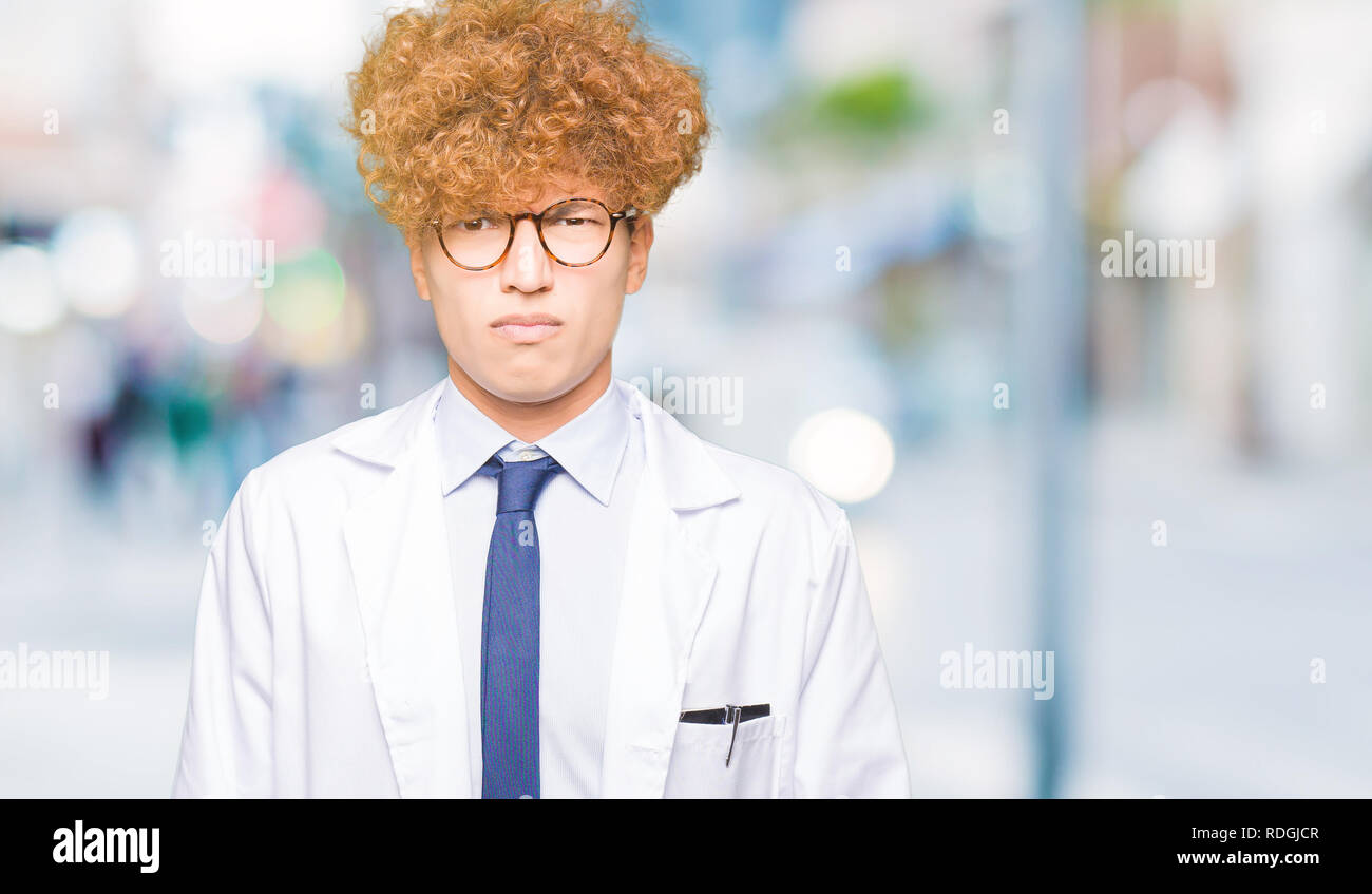 Young handsome scientist man wearing glasses skeptic and nervous ...