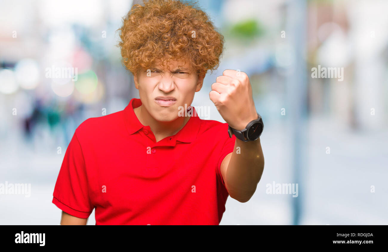 Young handsome man with afro hair wearing red t-shirt angry and mad ...