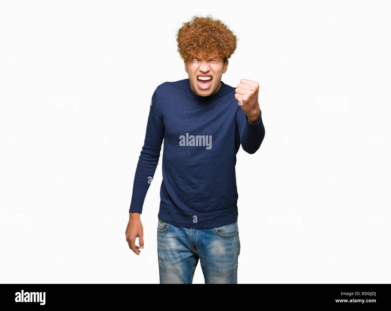 Young handsome man with afro hair angry and mad raising fist frustrated ...