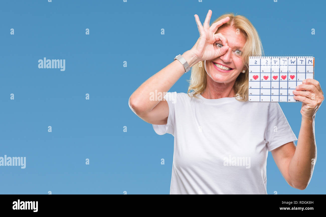 Middle age blonde woman holding menstruation calendar ver isolated ...
