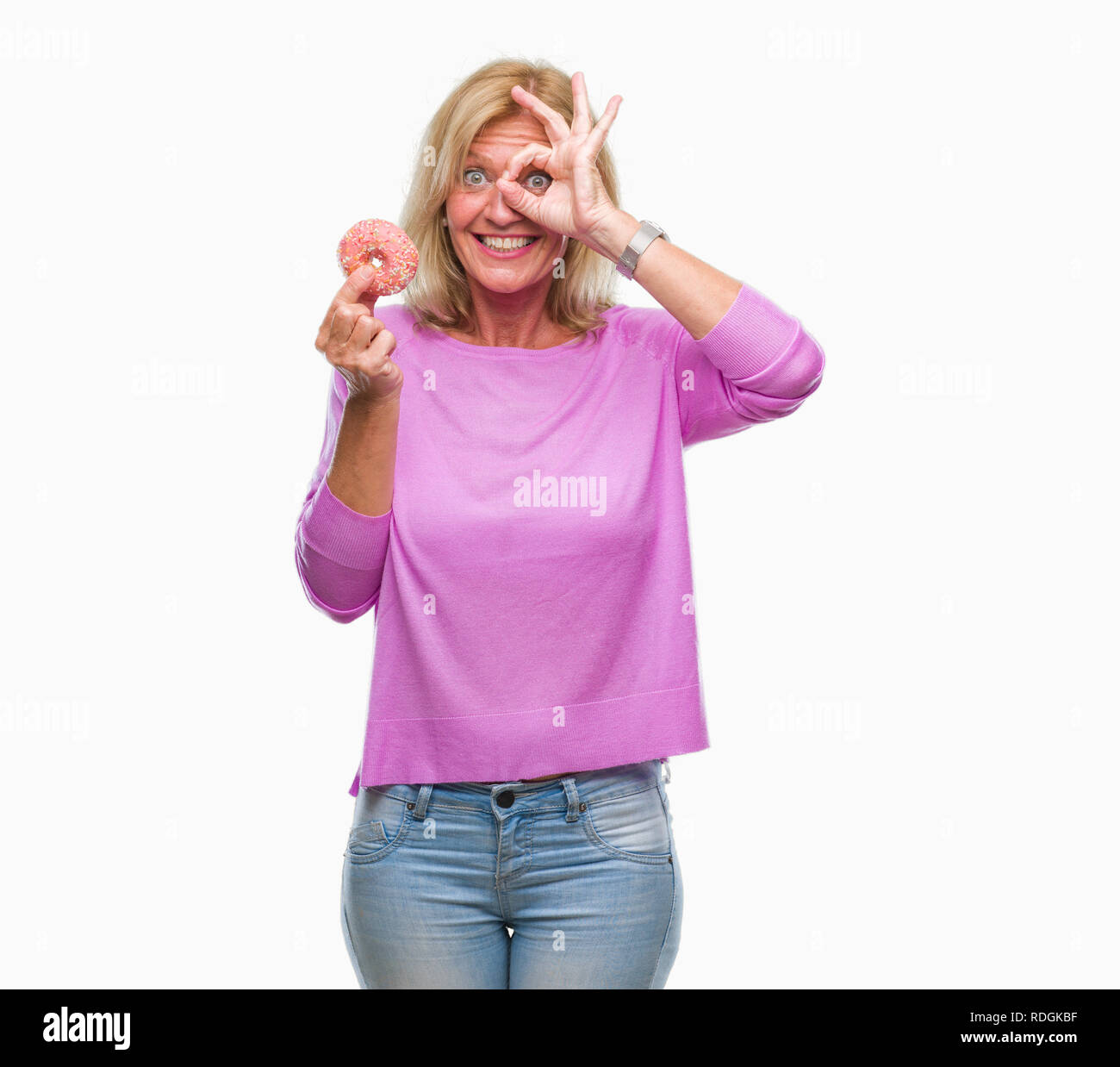 Middle age blonde woman eating pink donut over isolated background with ...