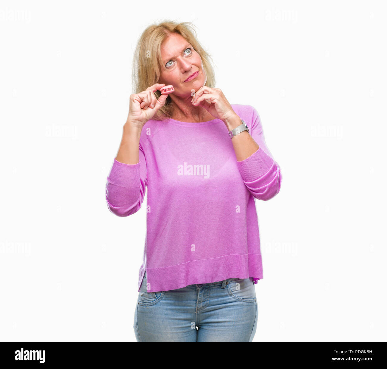 Middle age blonde woman eatin pink macaron biscuit over isolated ...