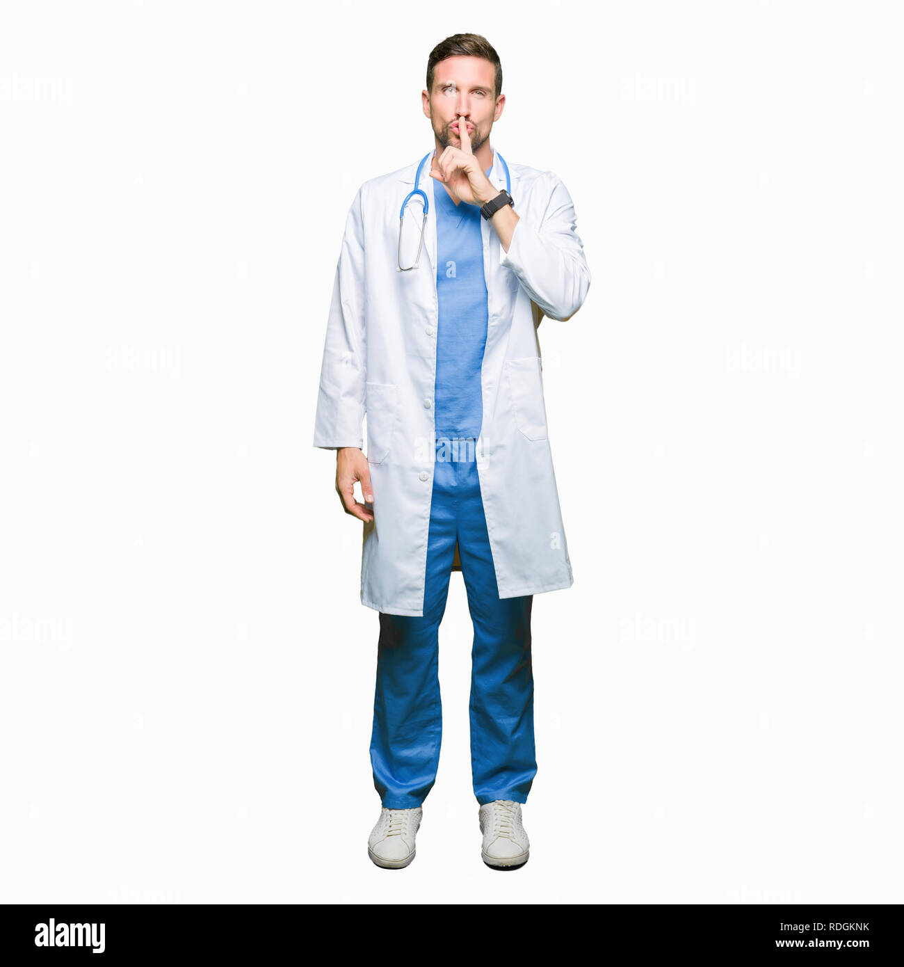 Handsome doctor man wearing medical uniform over isolated background ...