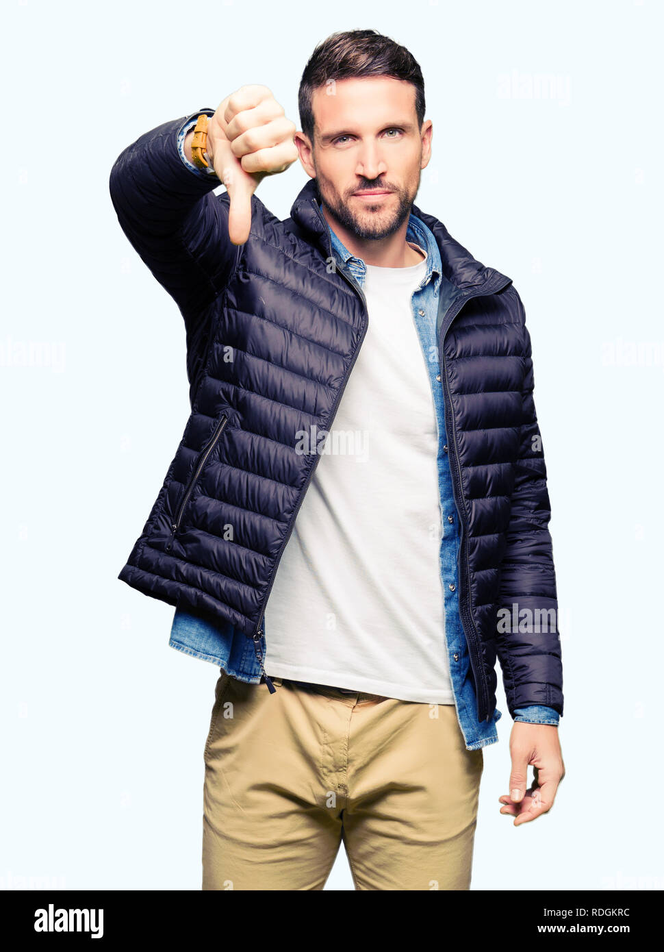 Handsome man wearing winter coat looking unhappy and angry showing ...