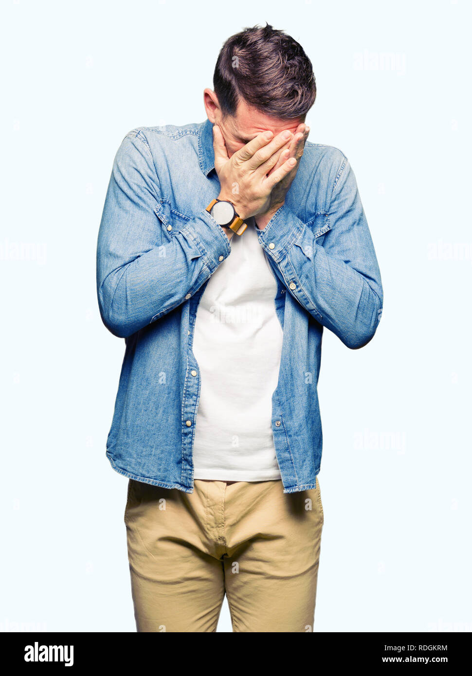 Handsome man with blue eyes and beard wearing denim jacket with sad ...