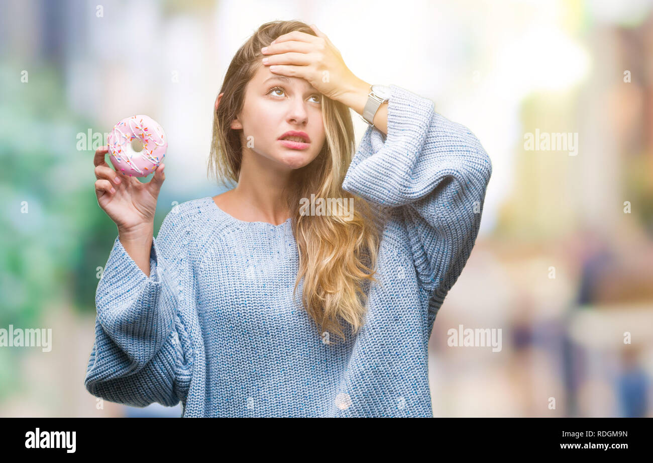 Young beautiful blonde woman eating sweet donut over isolated ...