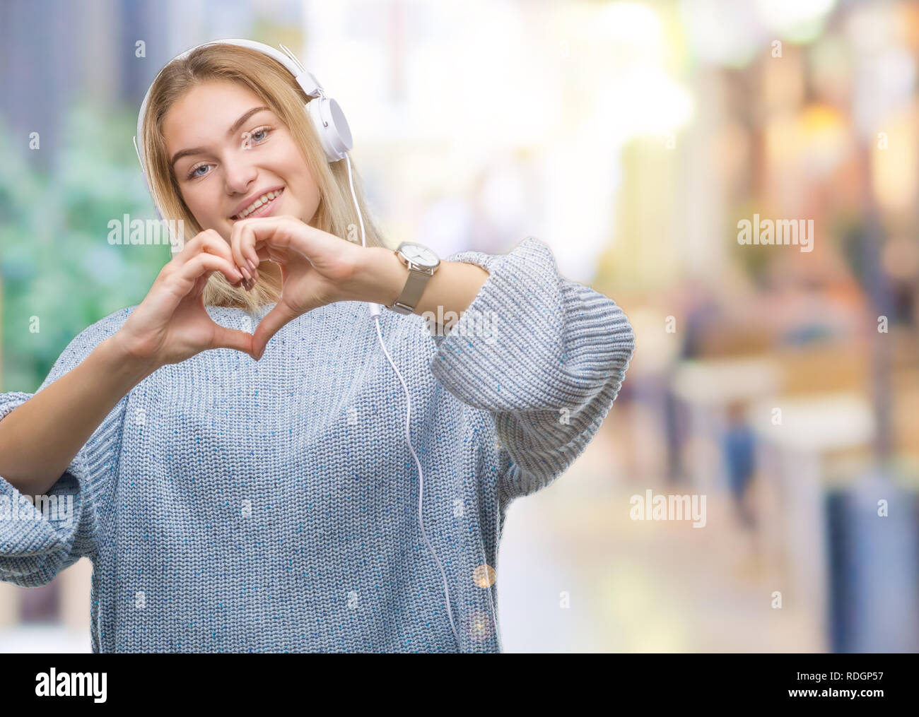 Young caucasian woman listening to music wearing headphones over ...