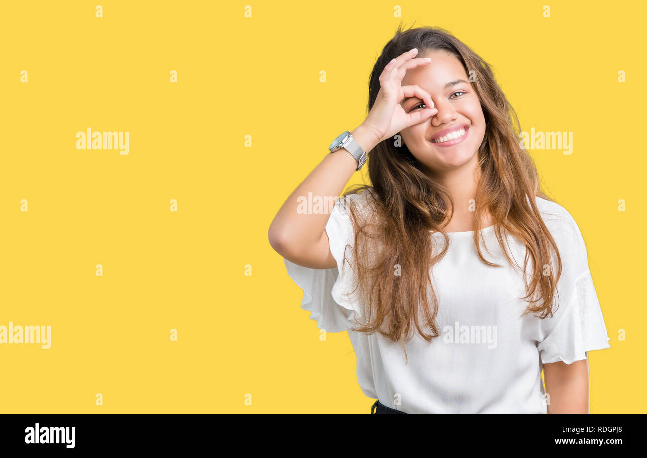 Young beautiful brunette business woman over isolated background doing ...