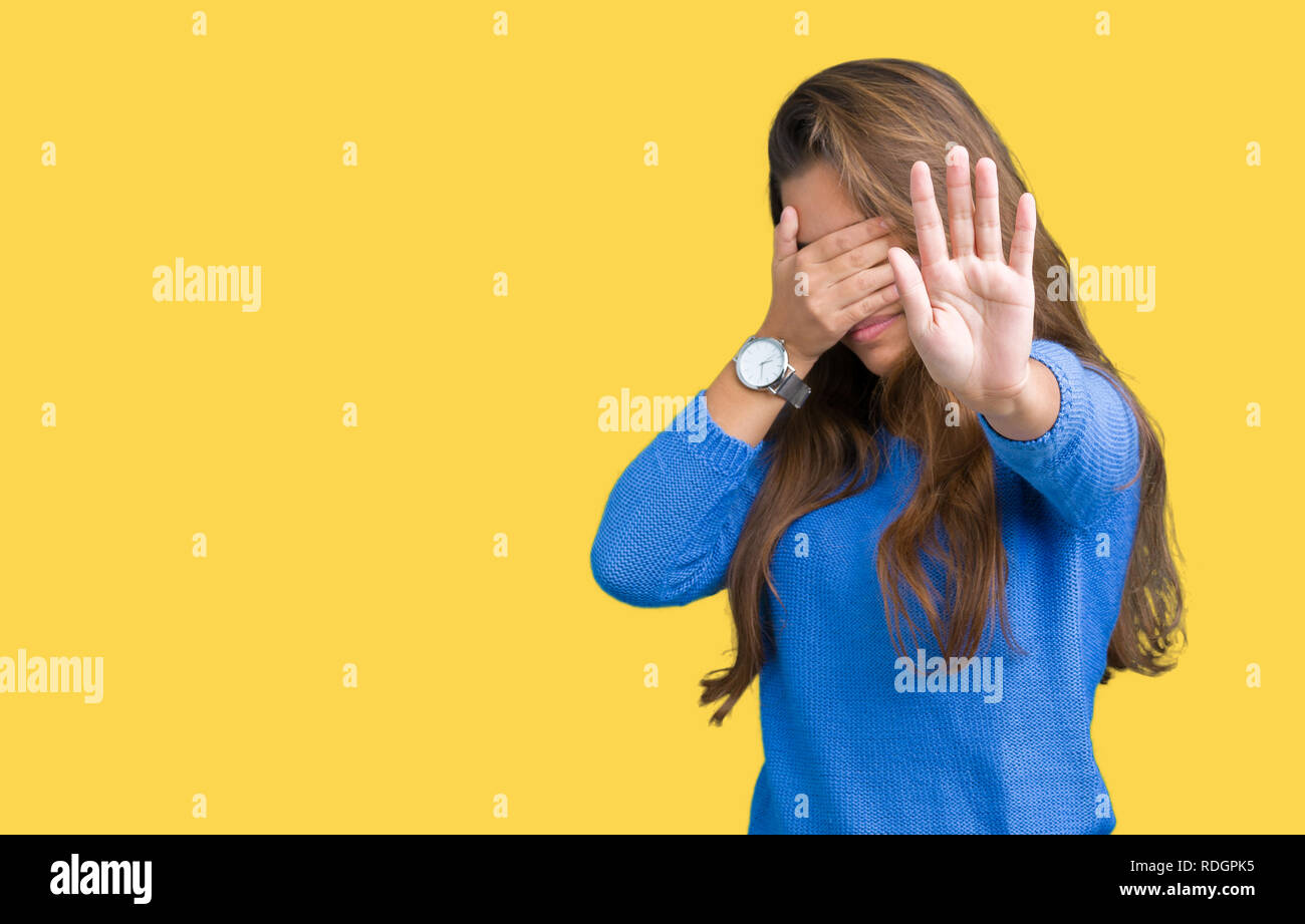 Young beautiful brunette woman wearing blue sweater over isolated ...