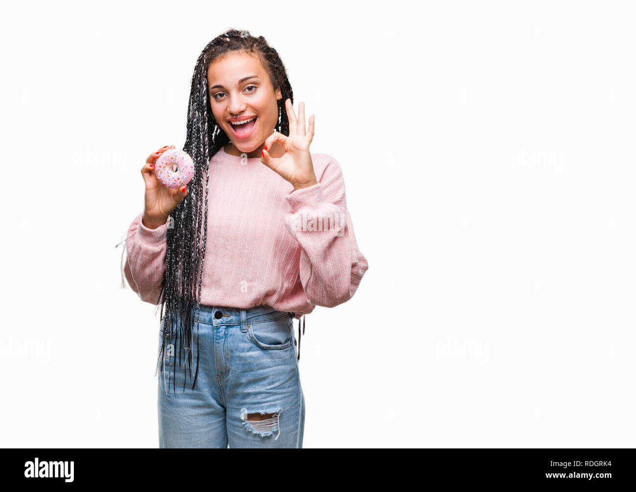 Young african american girl eating pink donut over isolated background ...