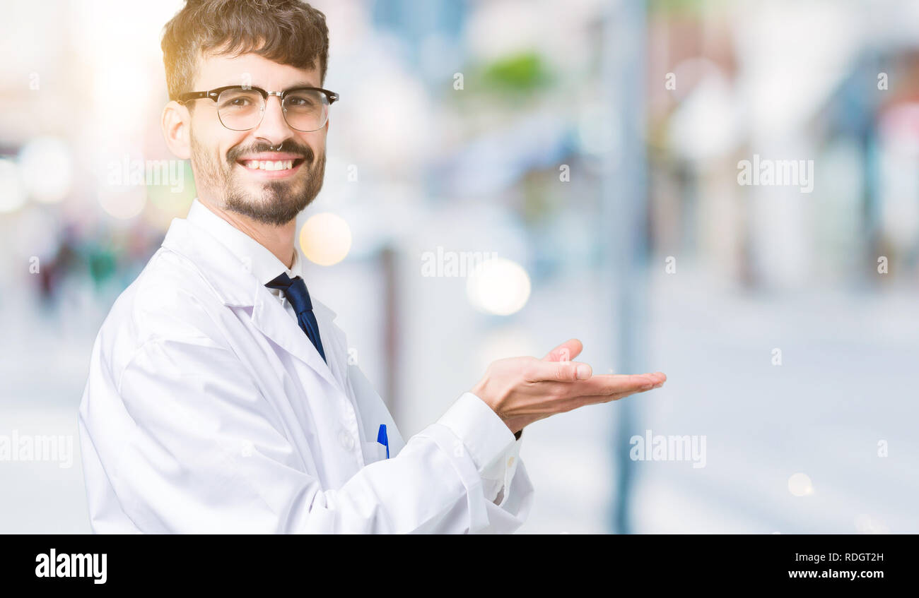 Young professional scientist man wearing white coat over isolated ...