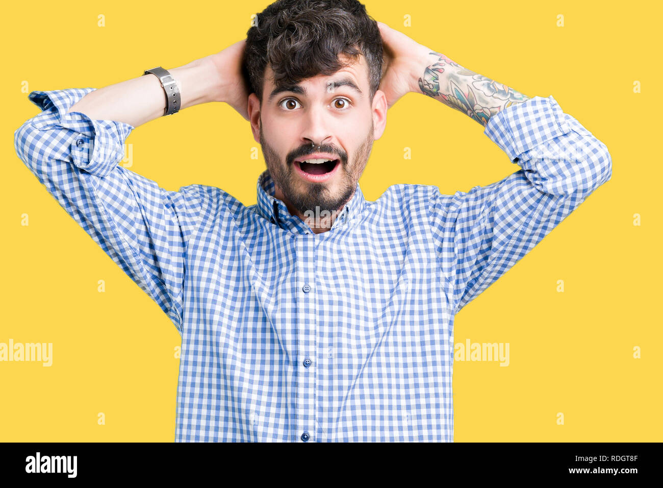 Young handsome business man over isolated background Crazy and scared with hands on head, afraid ...