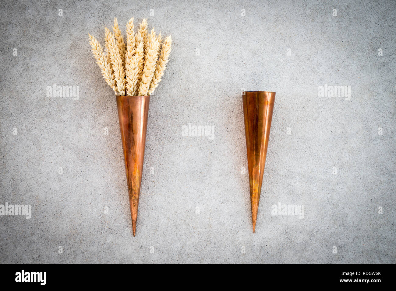 Two vintage copper cones with wheat ears, on concrete background Stock ...