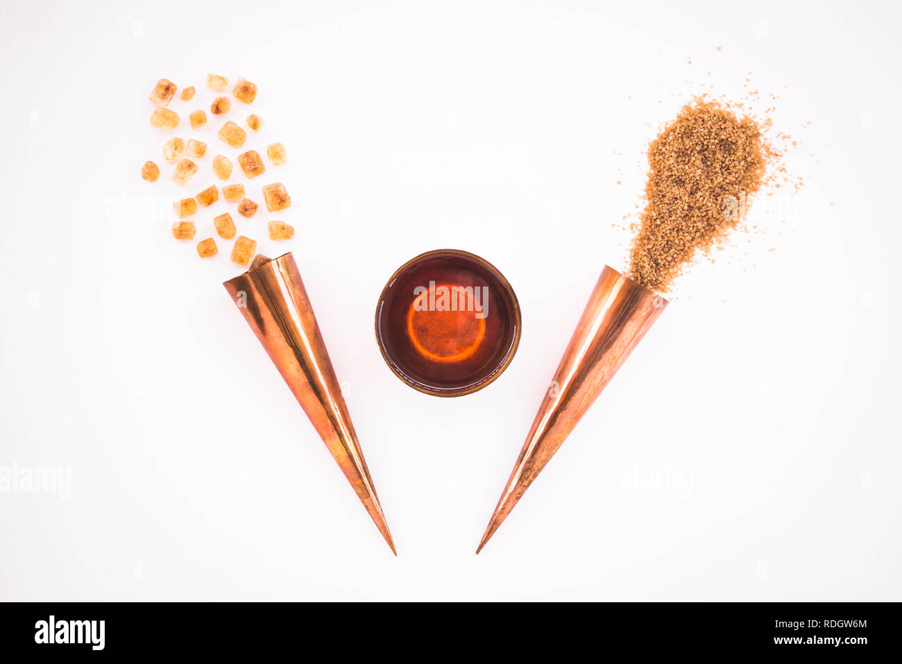 Cup of tea and copper cones with brown sugar, on white background Stock ...