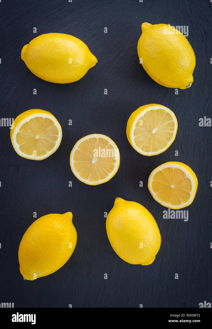 Whole and cut lemons on dark slate background. Ripe citrus fruits Stock ...