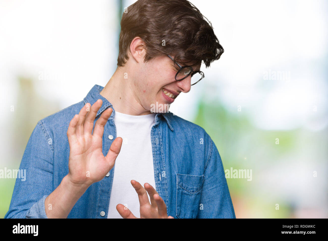 Young handsome man wearing glasses over isolated background disgusted ...