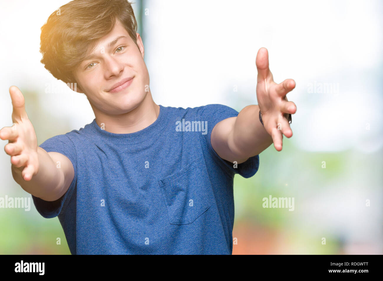 Young handsome man wearing blue t-shirt over isolated background ...