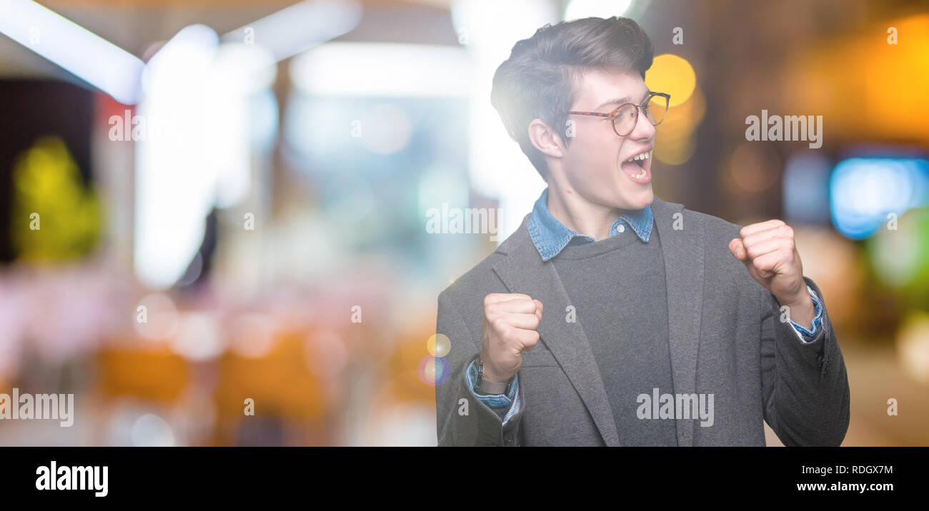 Young handsome business man wearing glasses over isolated background ...