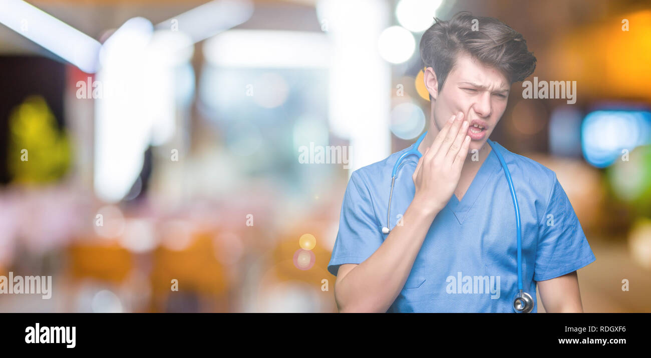 Young doctor wearing medical uniform over isolated background touching ...
